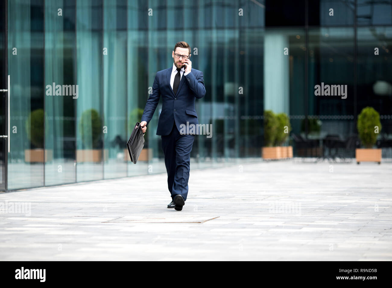 Business man going near office building Stock Photo - Alamy