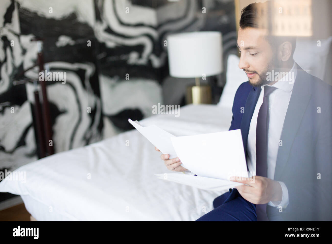 Professional young businessman reading documents hi-res stock ...