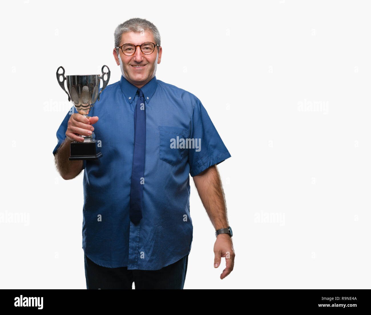 Handsome senior successful man holding trophy over isolated background ...