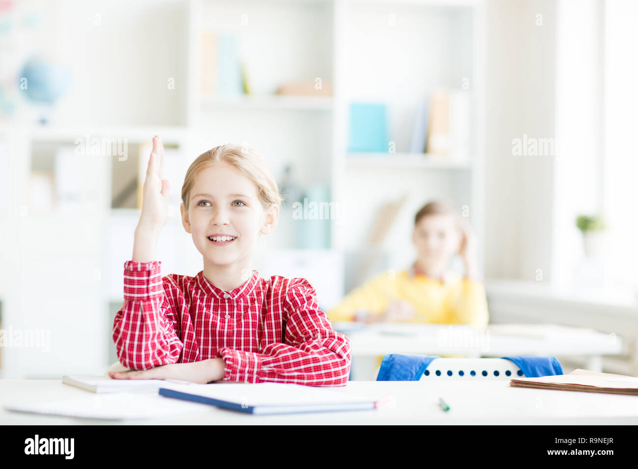 Girl raising hand Stock Photo - Alamy