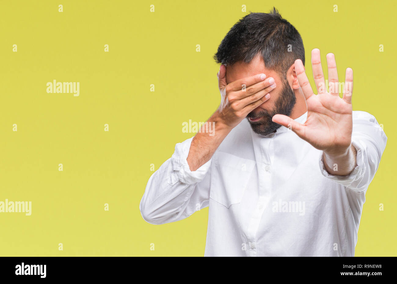 Adult hispanic man over isolated background covering eyes with hands ...