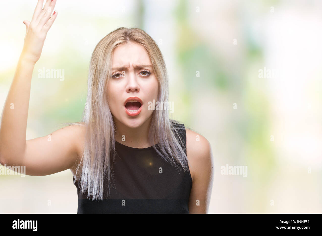Young blonde woman over isolated background angry and mad raising fist ...