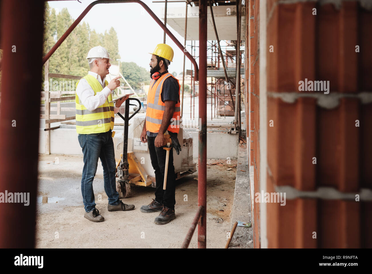 People working in construction site. Men at work in new house inside ...