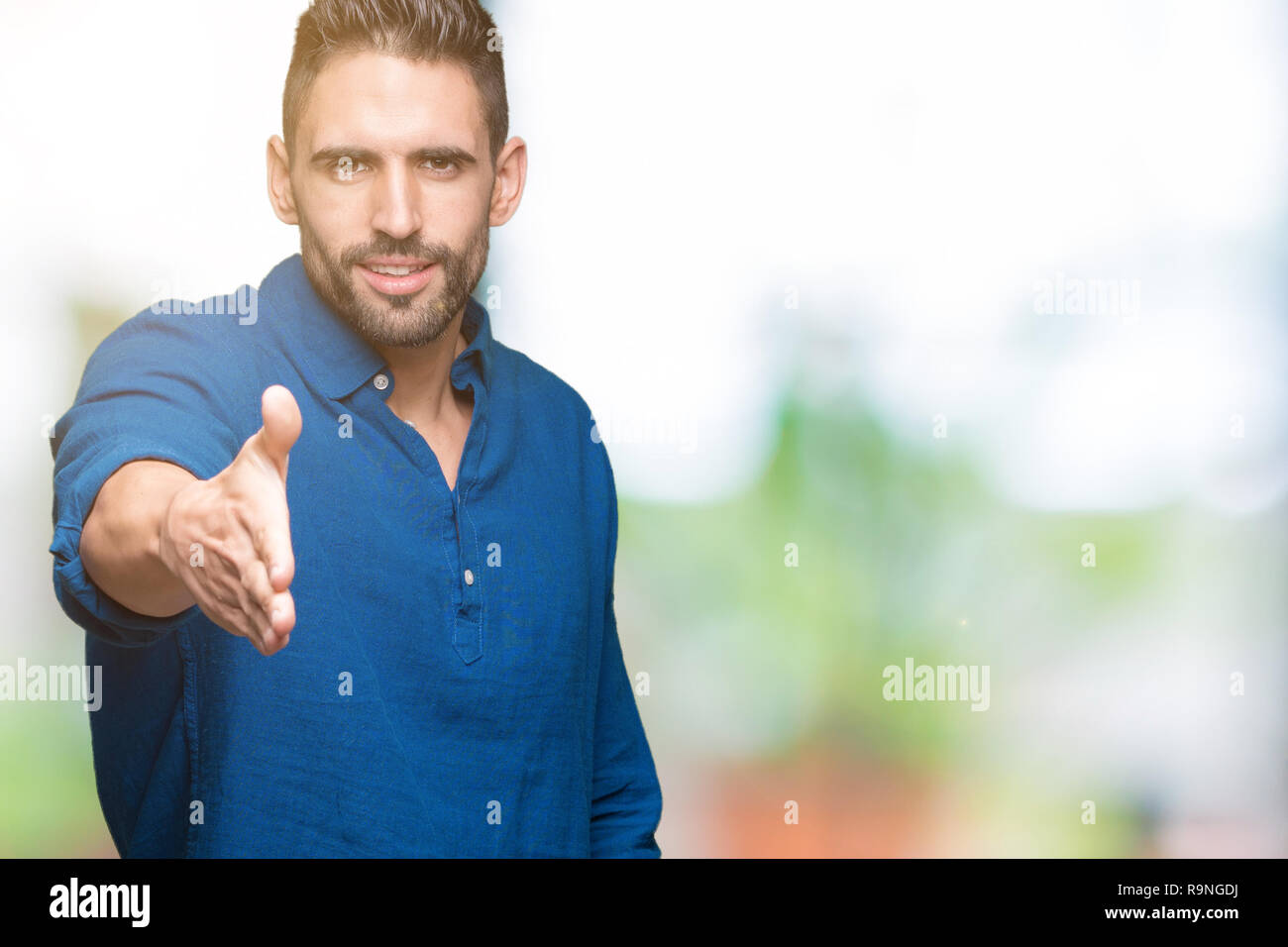 Young handsome man over isolated background smiling friendly offering ...