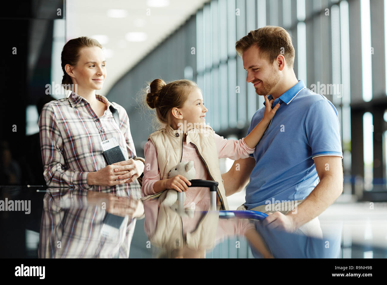 Family by check-in counter Stock Photo - Alamy