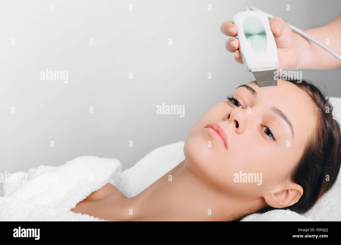 Beautiful woman receiving ultrasound skin cleaning, facial peeling ...