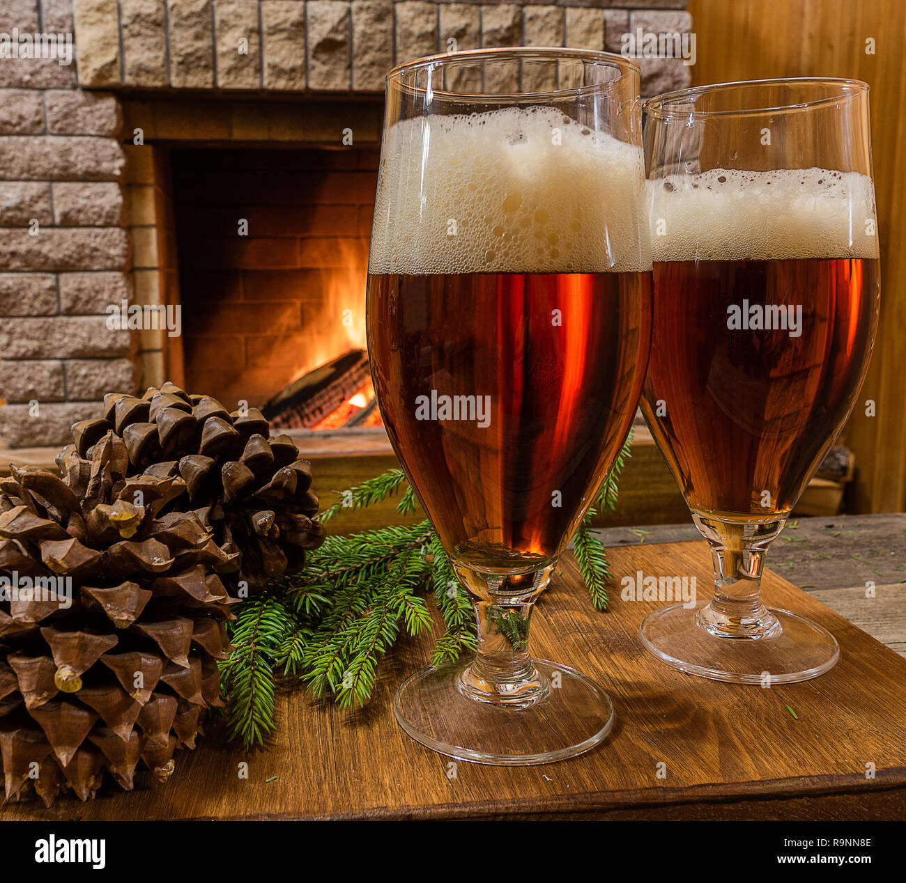Christmas. Cozy scene before cozy fireplace with two beer glasses ...