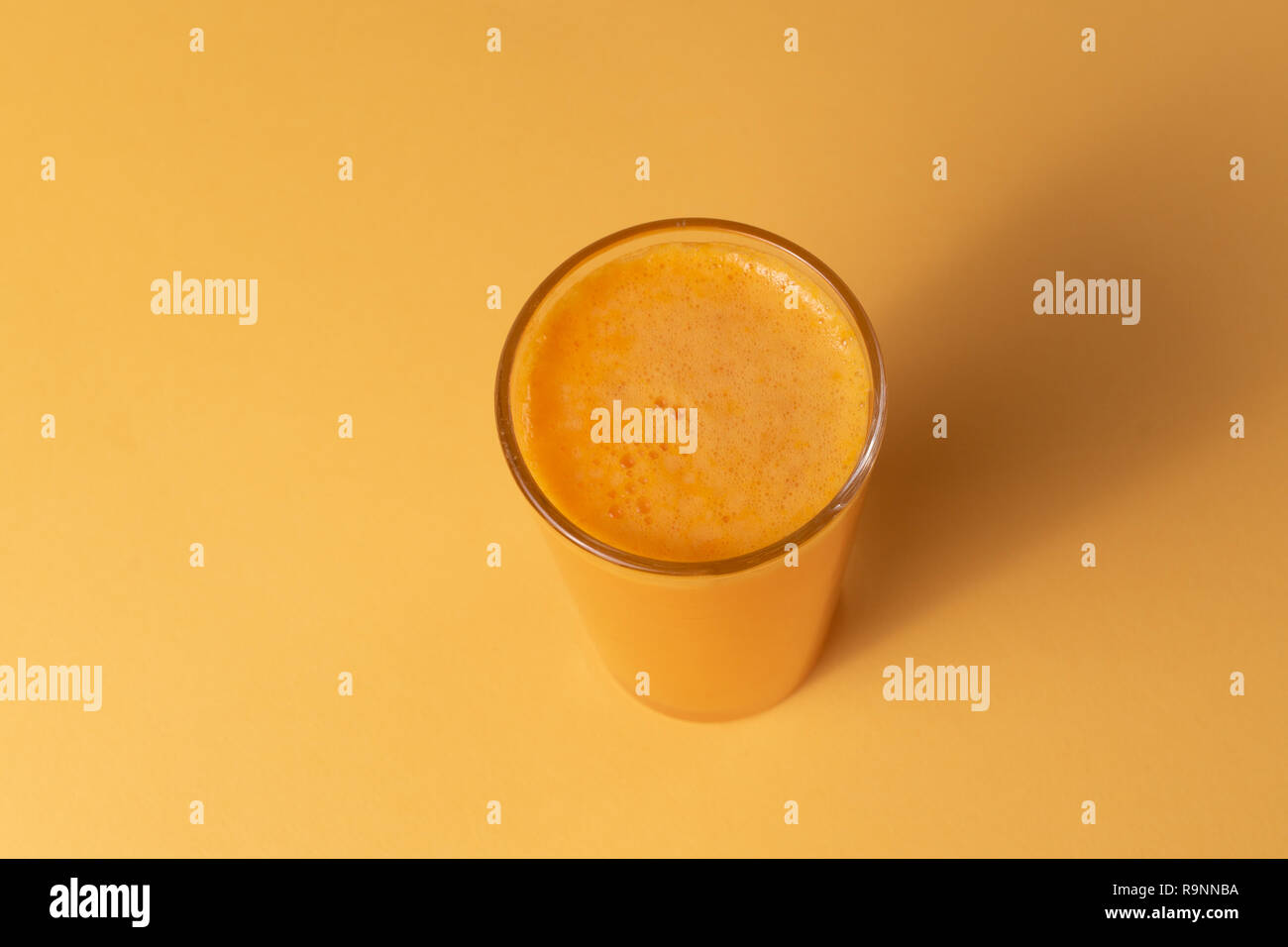 Flat lay view of Orange juice in a glass , over yellow background Stock ...
