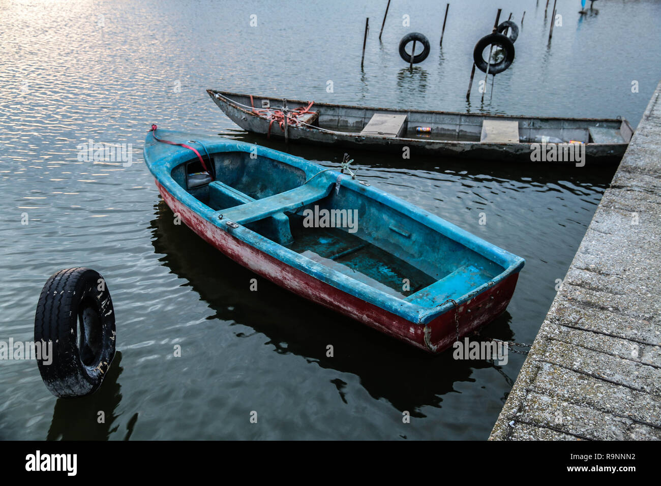 Small old wood fishing boats floating on the water. They are standing ...