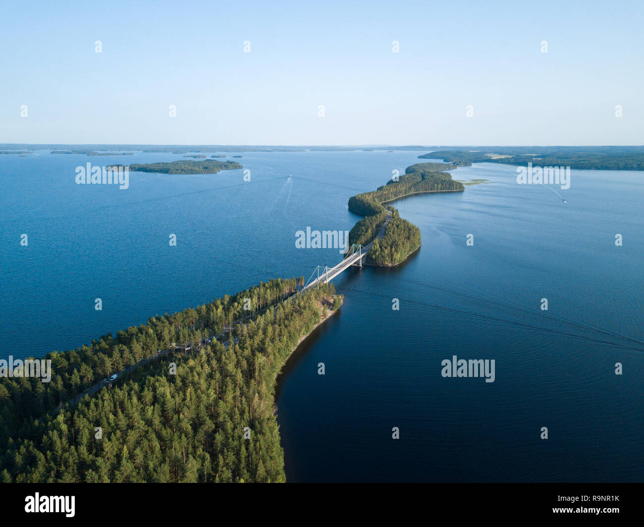 Scenic ridge road with a bridge crossing a lake in Finland. Aerial shot ...