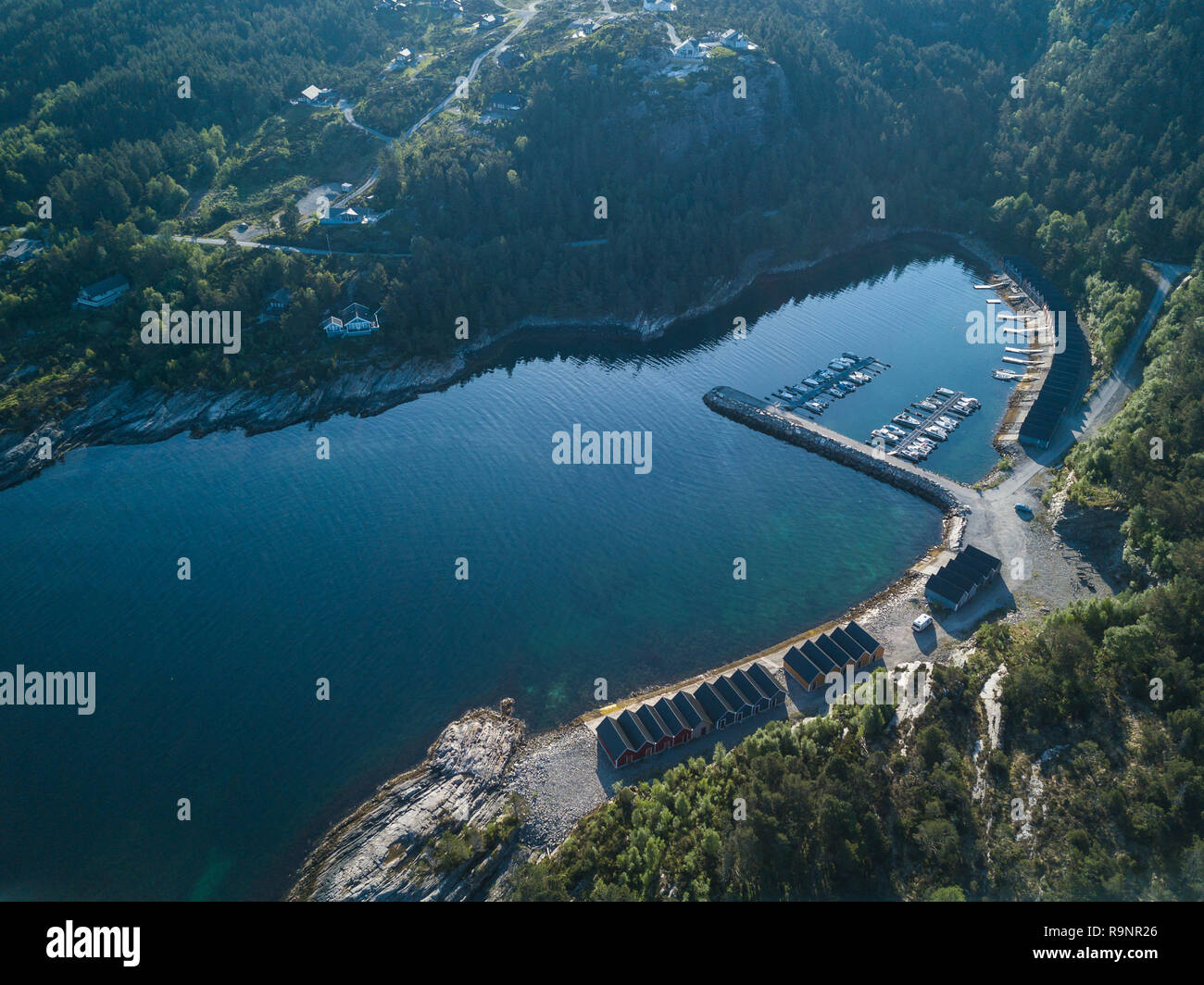 Calm bay and local boat harbour with boathouses on Norwegian coast near ...