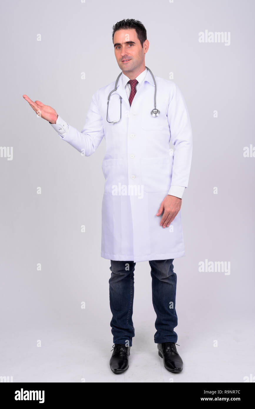 Full body shot of happy handsome man doctor showing something against ...