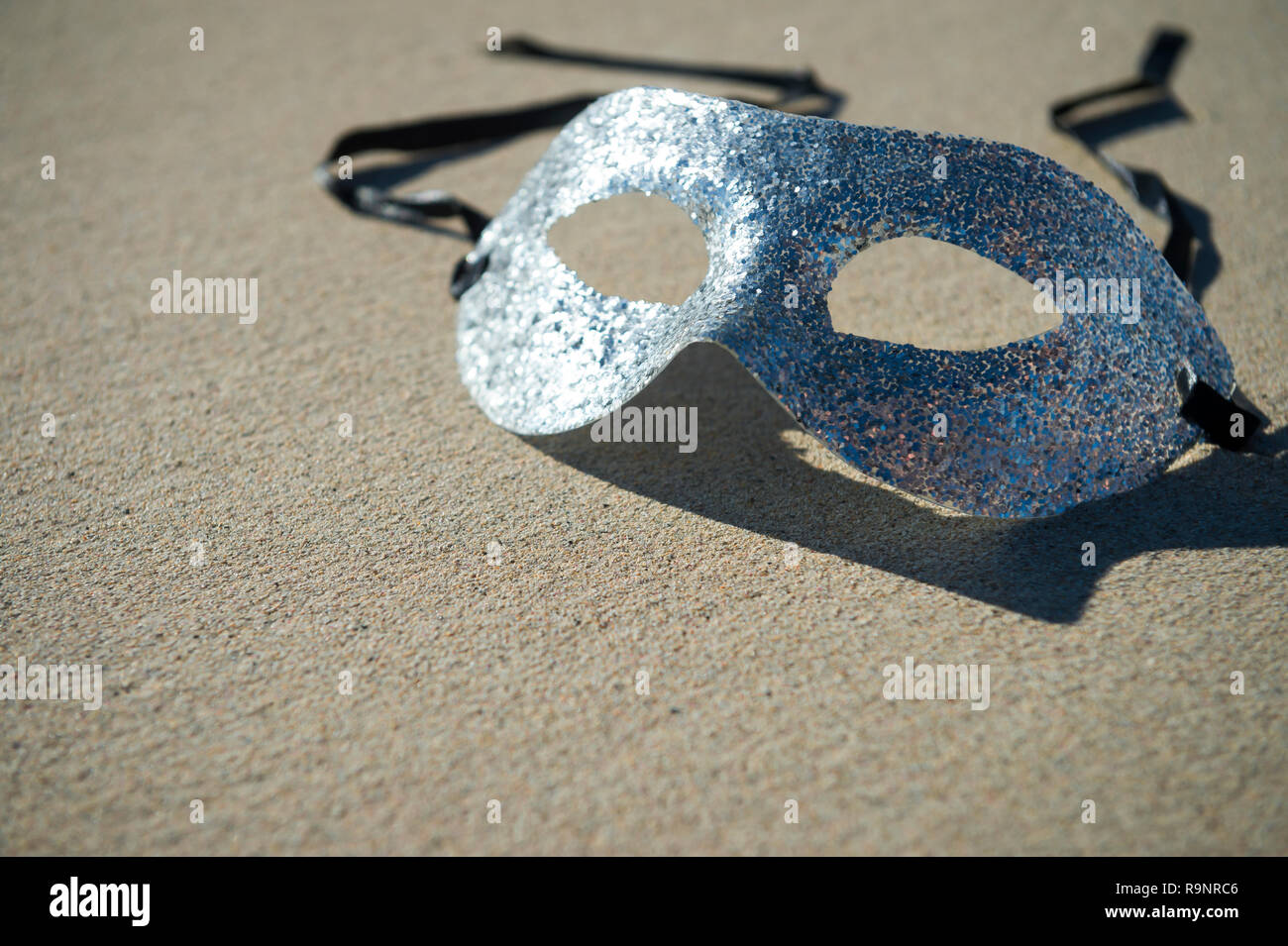 Sparkling silver carnival mask waiting in the tropical sun on textured ...