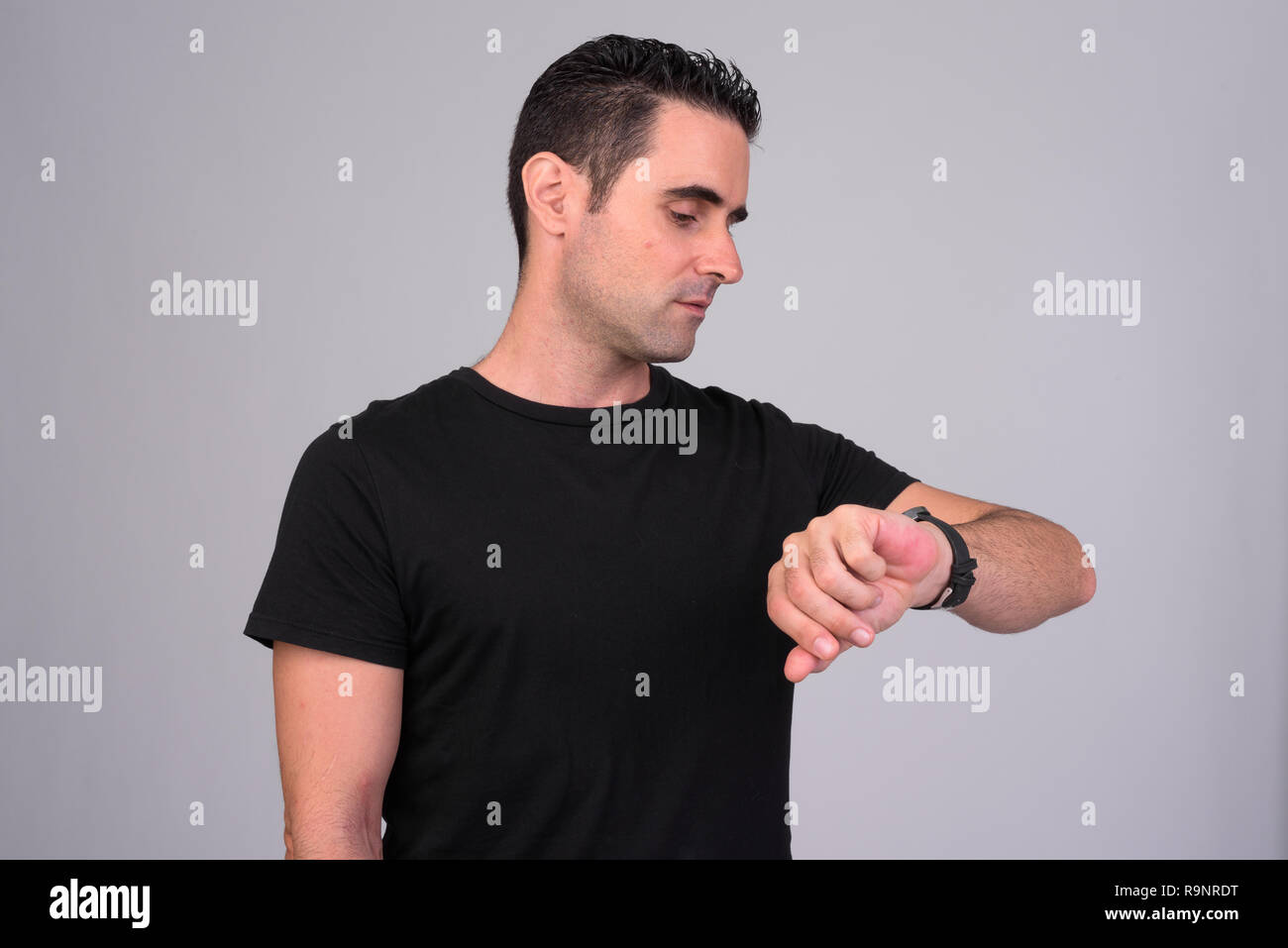 Portrait of handsome man checking time against white background Stock ...