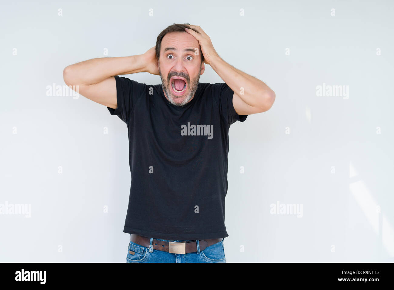 Senior man over isolated background Crazy and scared with hands on head ...