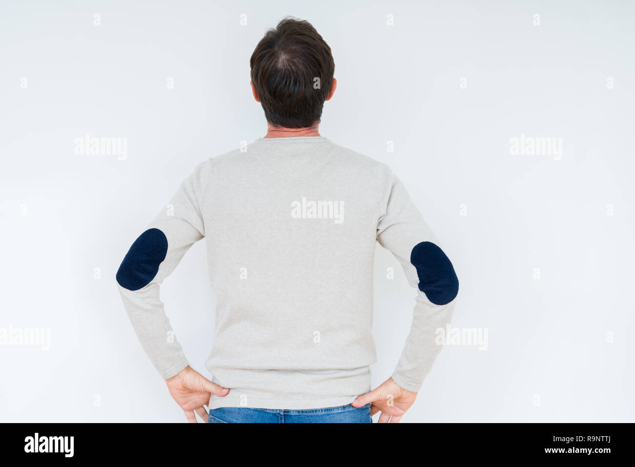 Elegant senior man over isolated background standing backwards looking ...