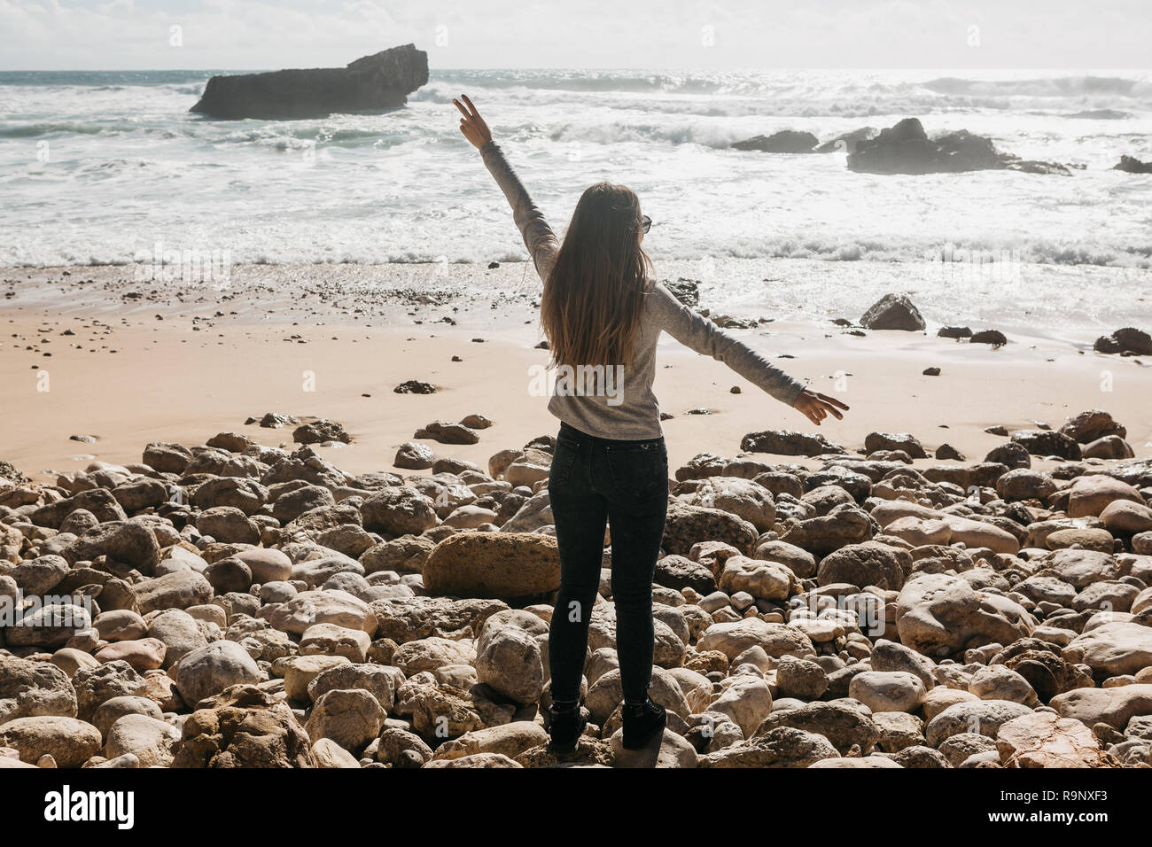 Rear view of a girl admiring the beautiful view of the Atlantic Ocean ...