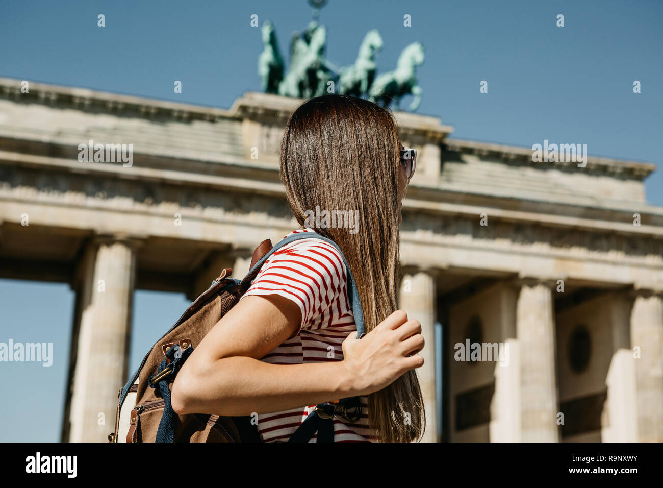 A tourist or a student with a backpack near the Brandenburg Gate in ...