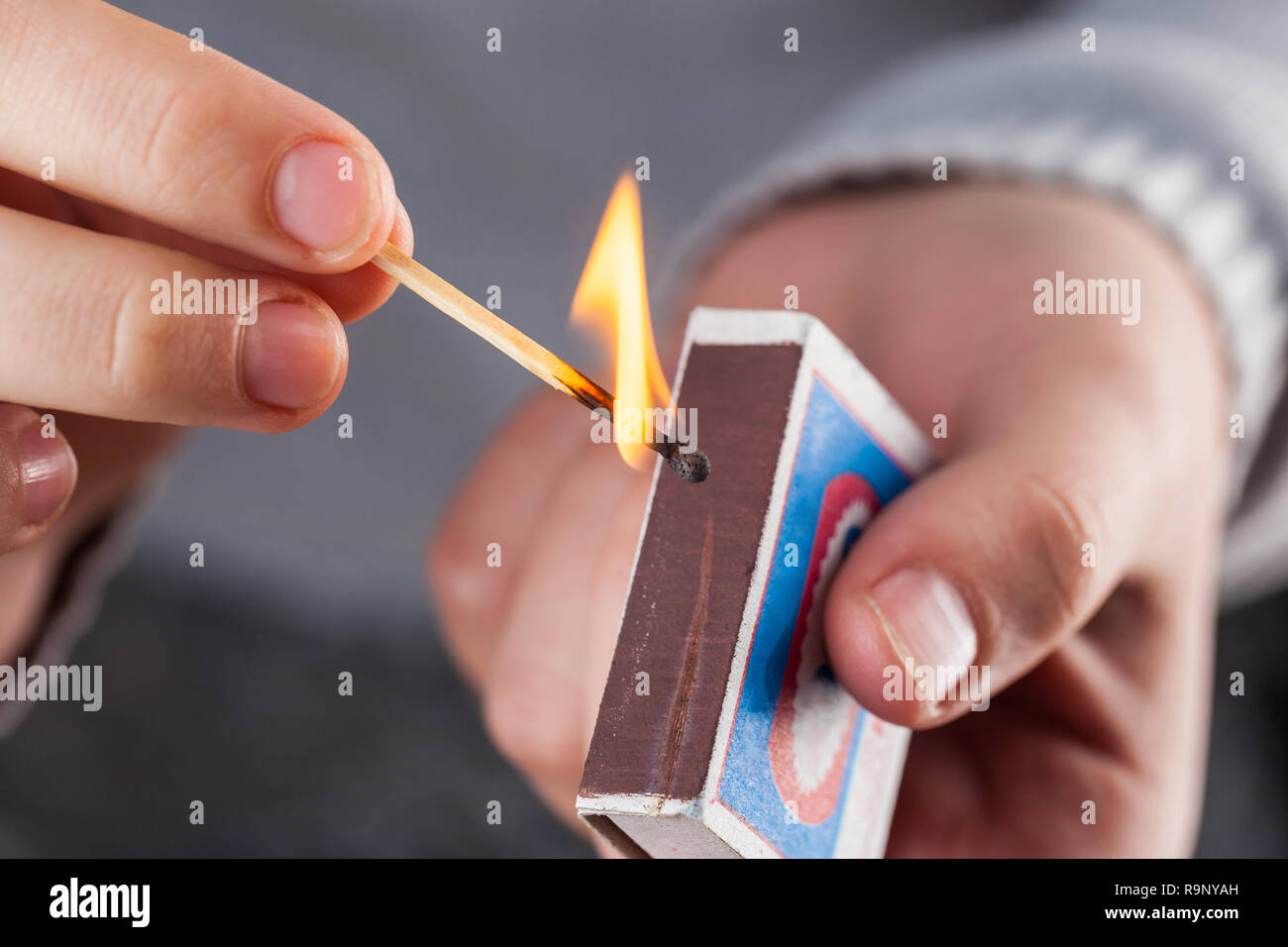 hold a matchbox while striking a match Stock Photo - Alamy