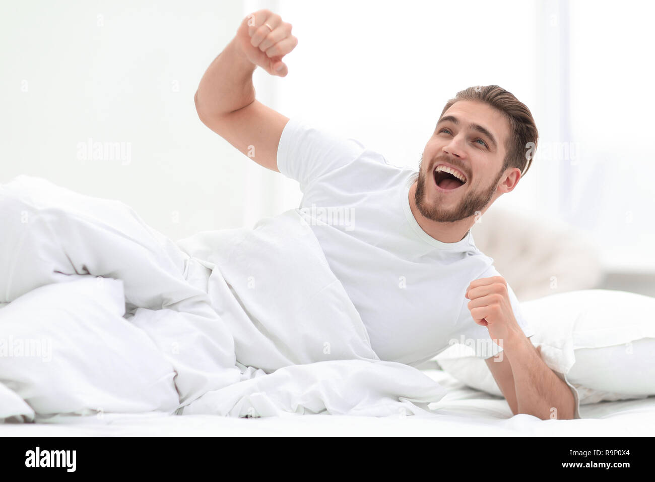 handsome man waking up in a cosy bedroom Stock Photo - Alamy