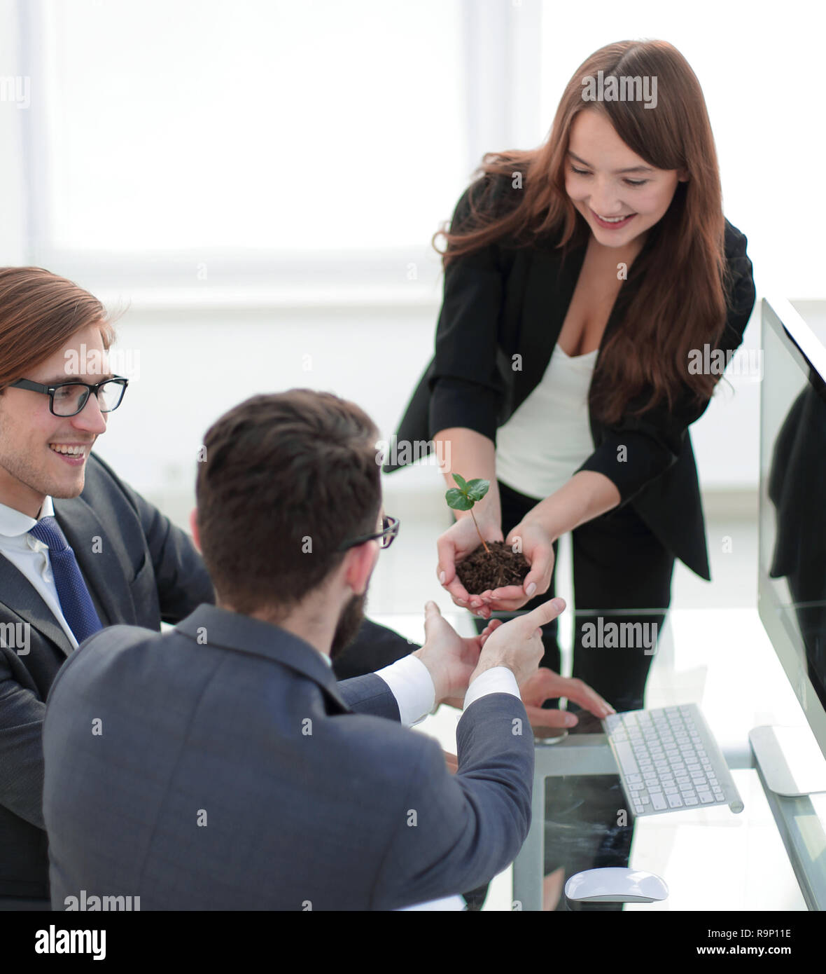 vertical photo.a happy employee is showing fresh sprout Stock Photo - Alamy