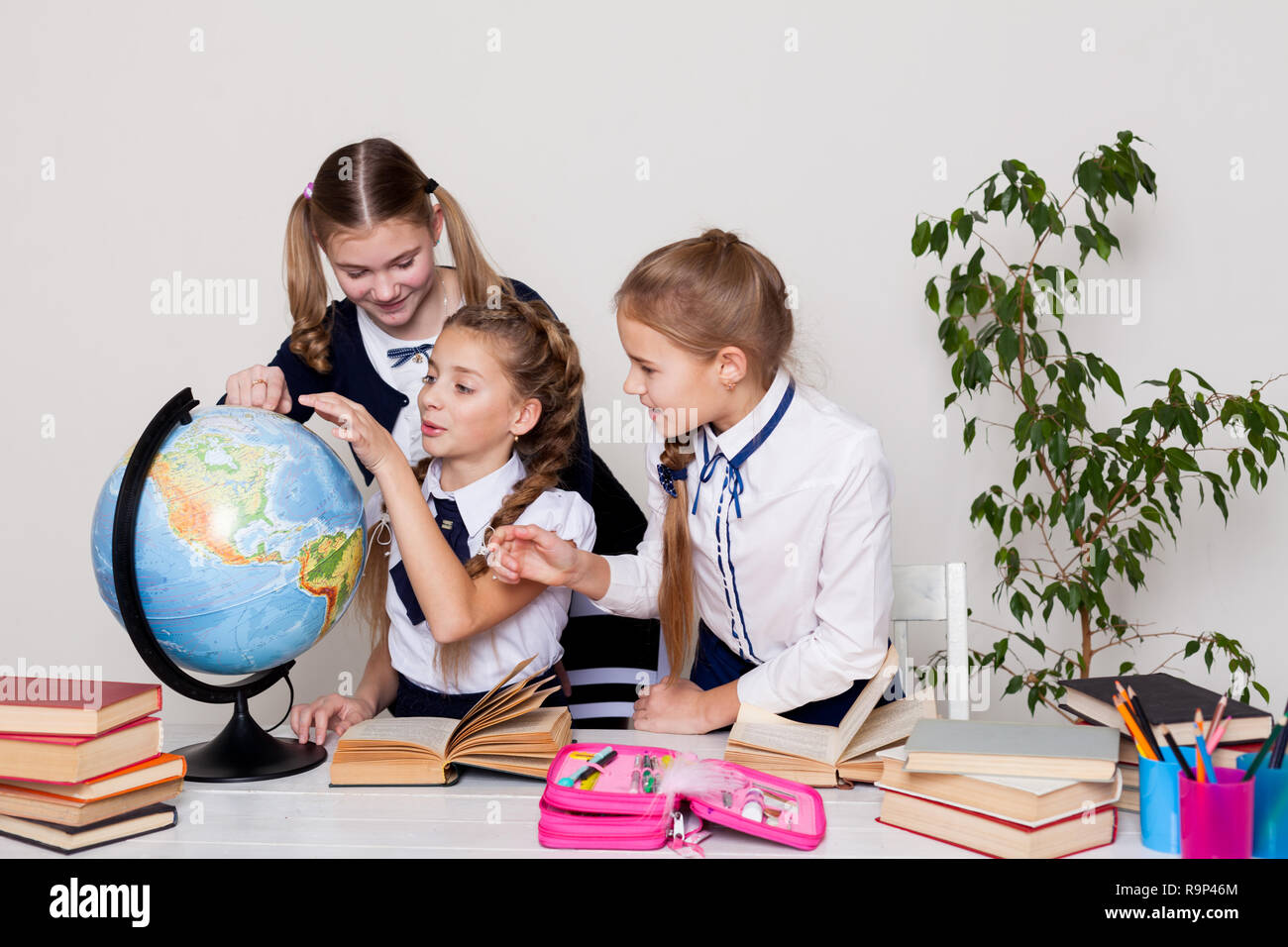 three schoolgirls girls learn world geography lesson on the map Stock ...