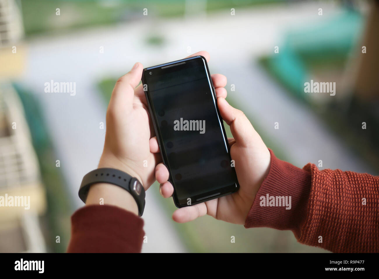 Boy is holding smartphone in hand Stock Photo - Alamy