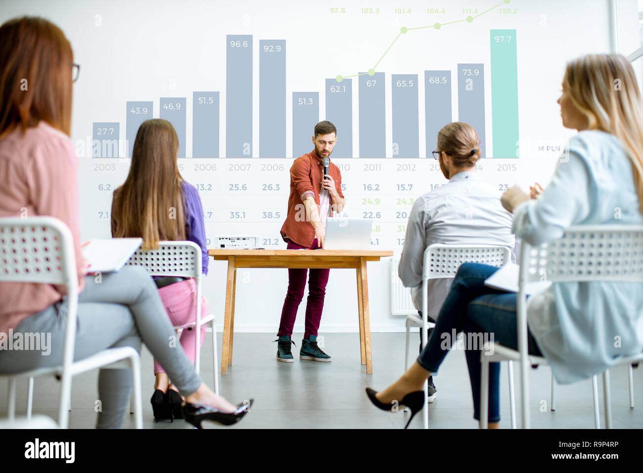 Young male speaker reporting to the audience during the meeting in the ...