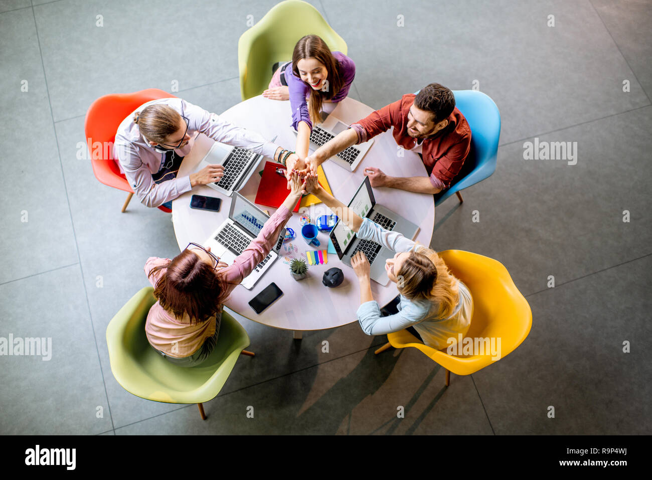 Team of a young coworkers dressed casually working together with ...