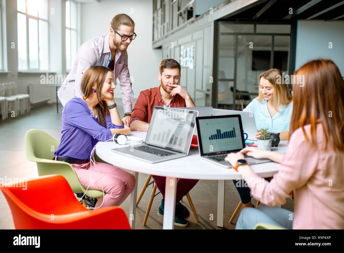 Team of a young coworkers dressed casually working together with ...