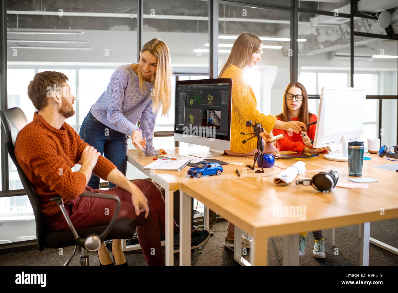 Group of a young coworkers dressed casually modeling 3d project working ...