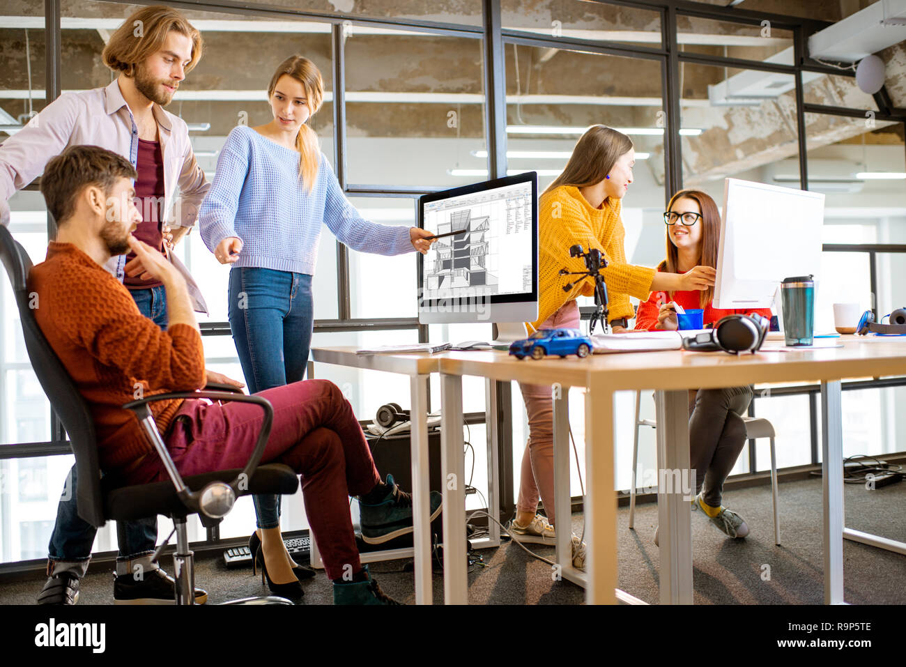 Group of a young coworkers working together on architectural project ...