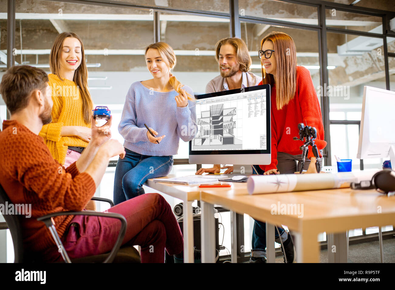 Group of a young coworkers working together on architectural project ...