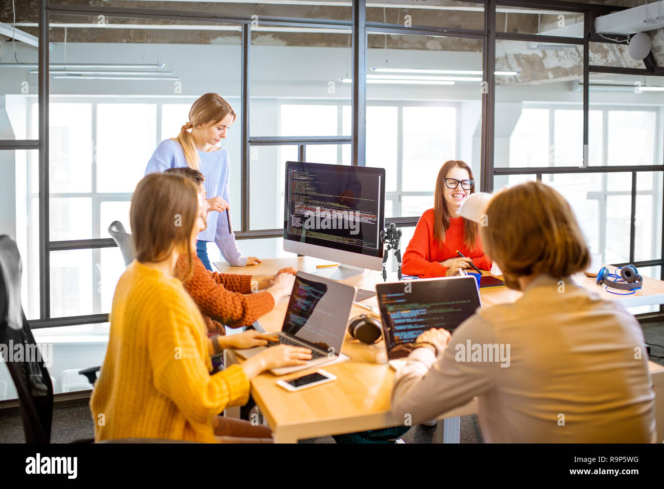 Team of a young programmers dressed casually working on computer code ...