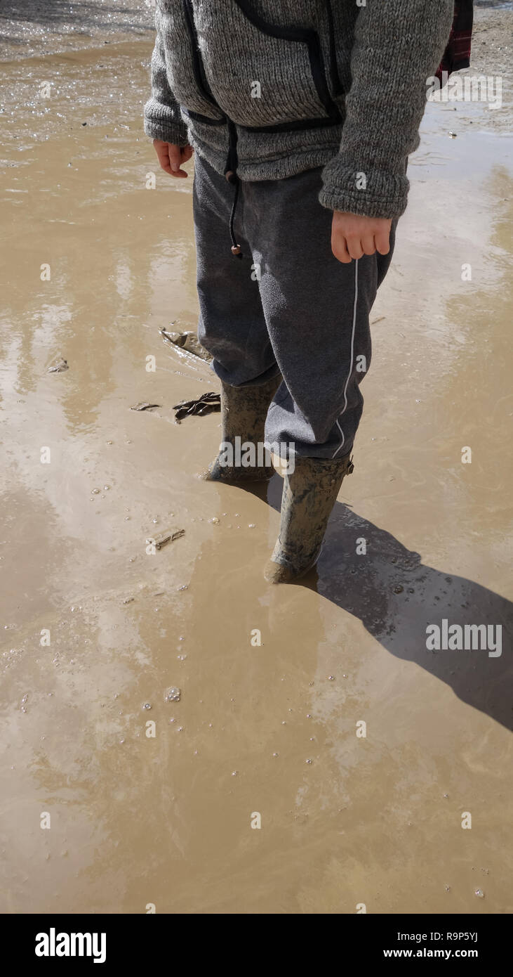 Low section of a person ankle-deep in a muddy puddle Stock Photo - Alamy