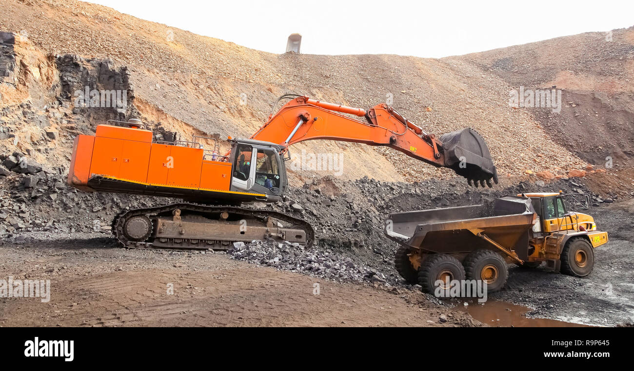 Excavator digging and loading ore rocks on a Manganese mine Stock Photo ...