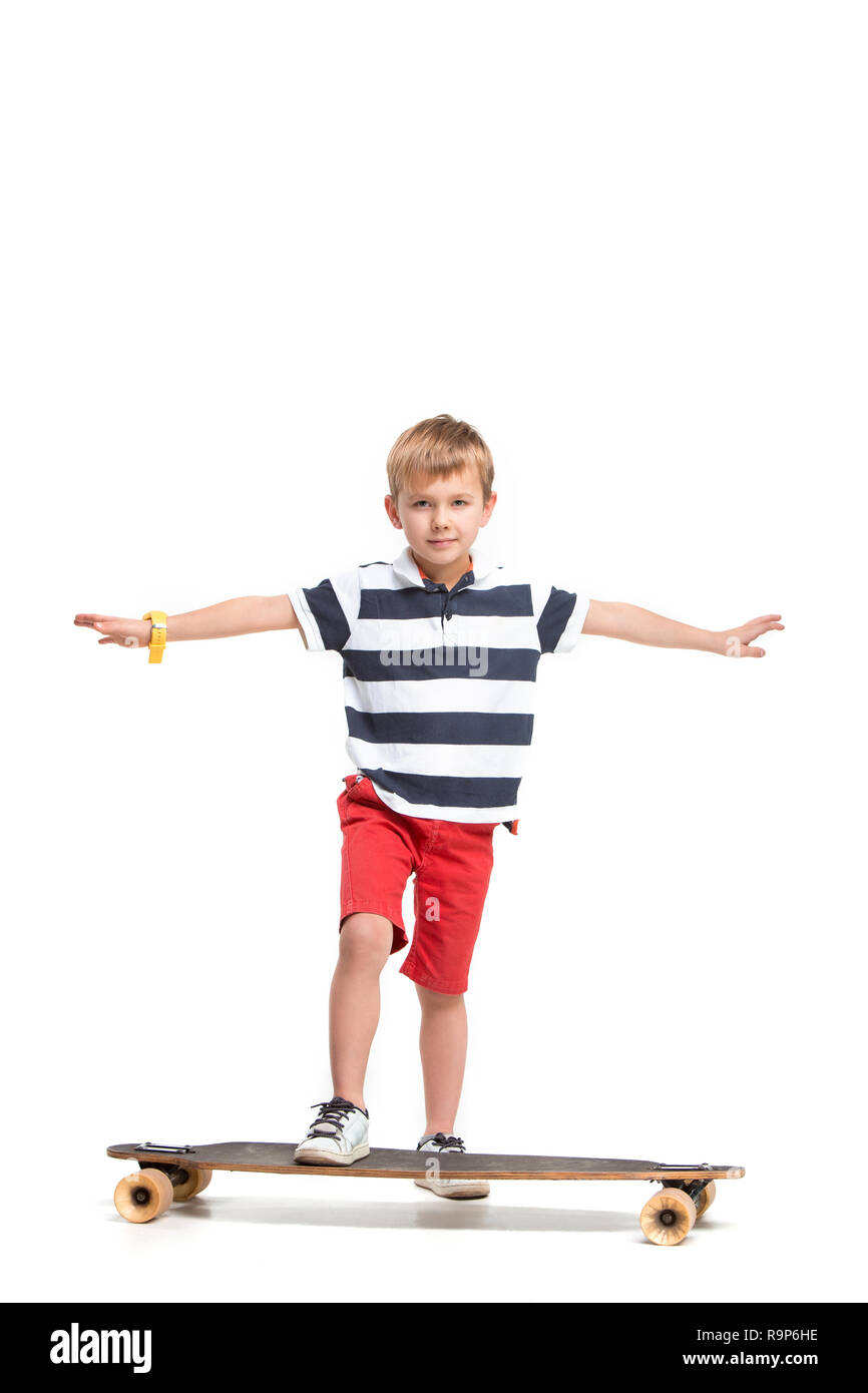 Full length portrait of an adorable young boy riding a skateboard ...