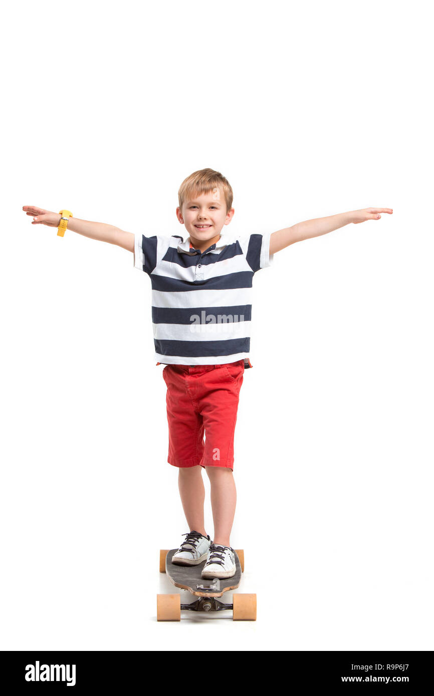 Full length portrait of an adorable young boy riding a skateboard ...