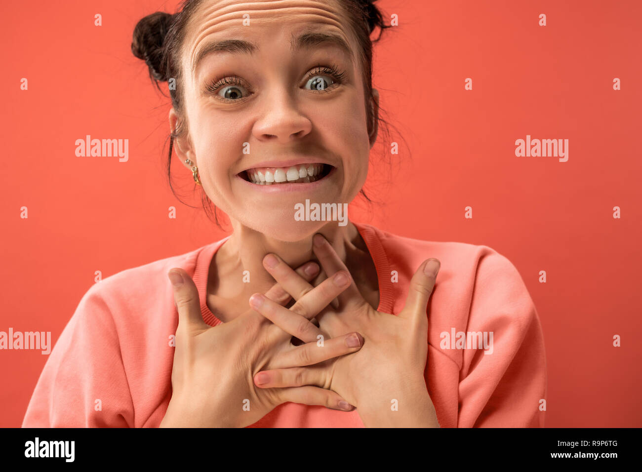 Delight. Beautiful female half-length front portrait isolated on coral ...