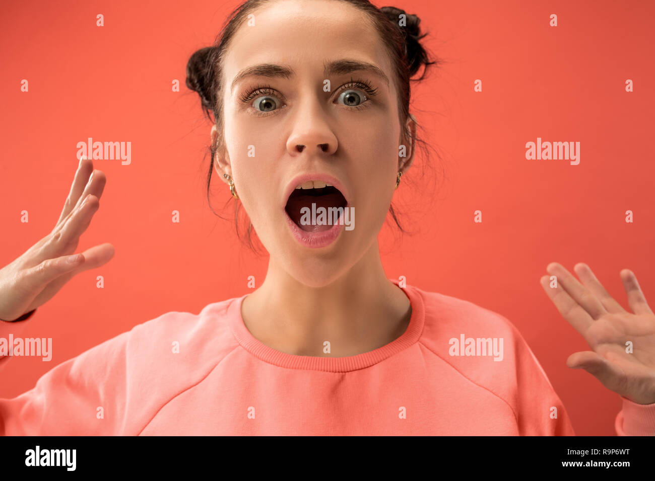 Delight. Beautiful female half-length front portrait isolated on coral ...