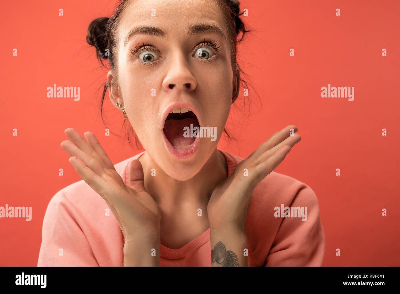 Delight. Beautiful female half-length front portrait isolated on coral ...