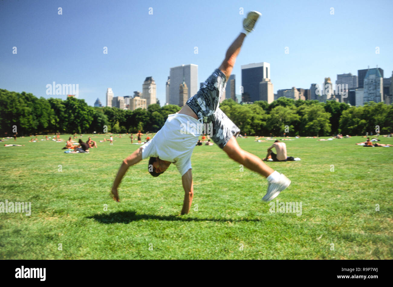 Teenage boy performs cartwheel on the Sheep Meadow in Central Park, NYC ...