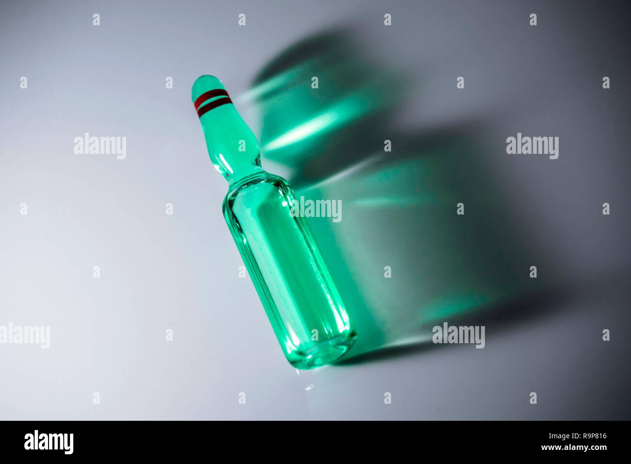 Vial detail with yellow medication, isolated side shadow on white ...