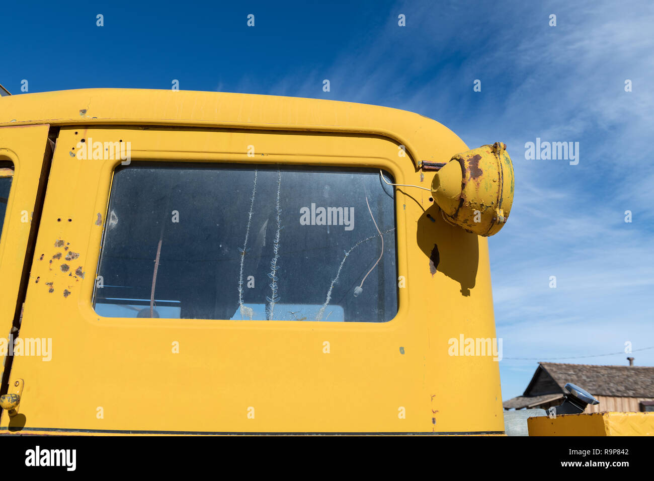 The cracked rear cab window of a rusty yellow antique truck Stock Photo ...