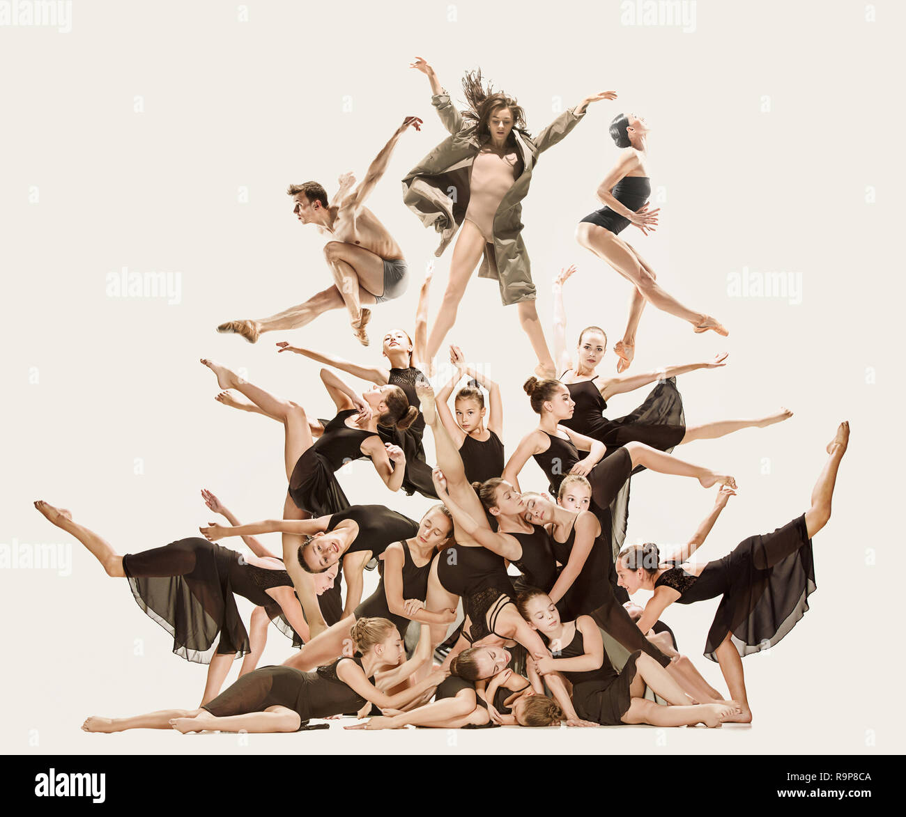 The group of modern ballet dancers dancing on gray studio background ...