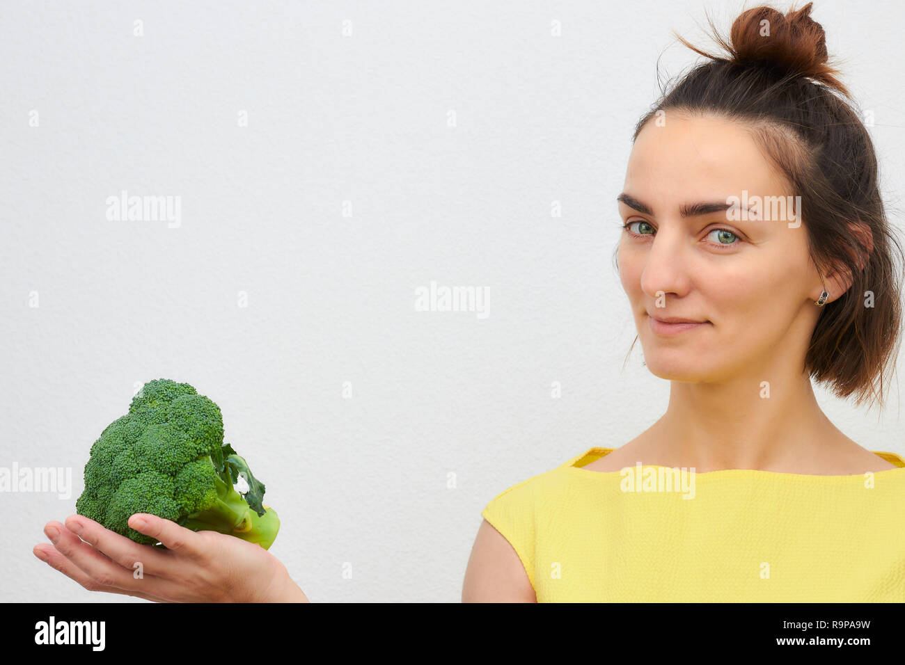cheerful, beautiful, slim, girl holding broccoli inflorescences in her ...