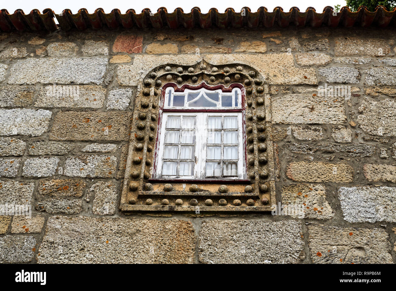 Manueline style window in the narrow streets of the medieval village of ...