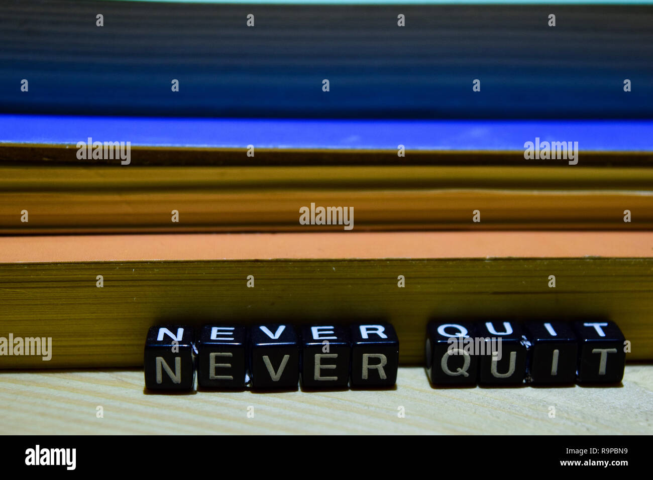 Never quit written on wooden blocks. Education and business concept on ...