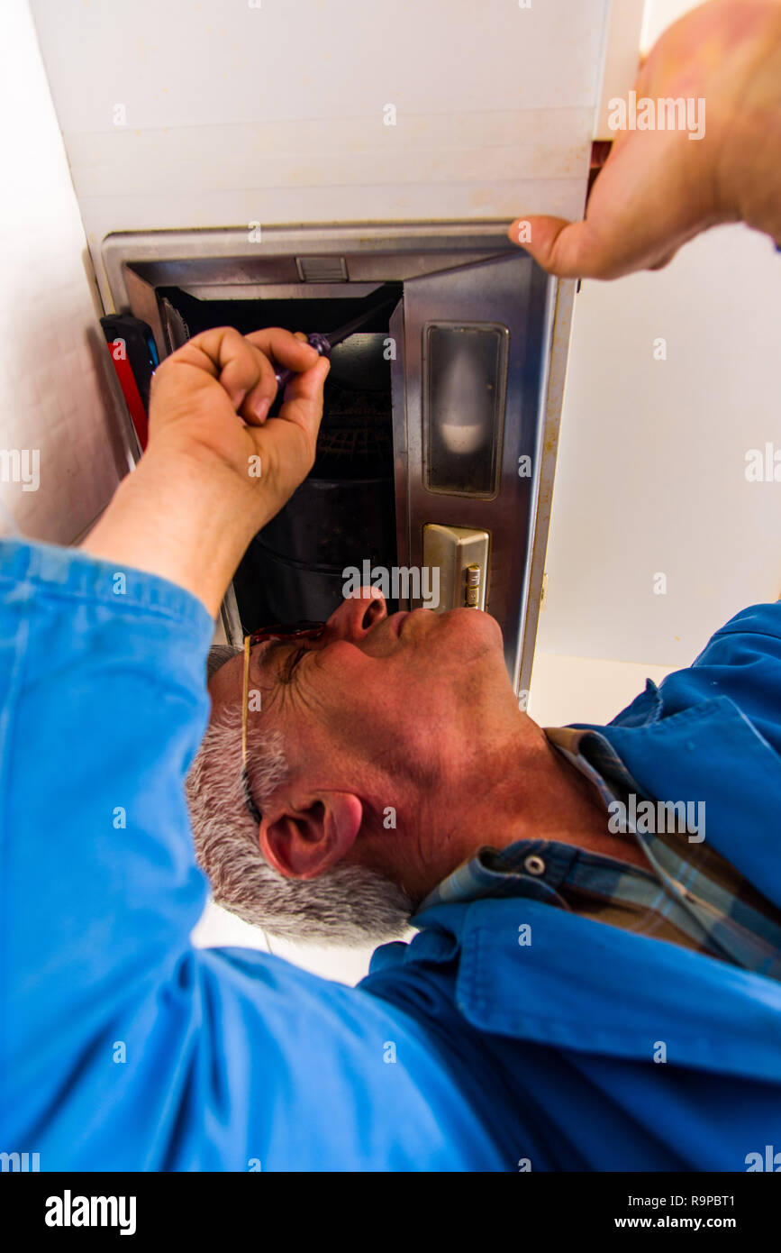 Senior handyman fixing the household appliances in apartment Stock ...