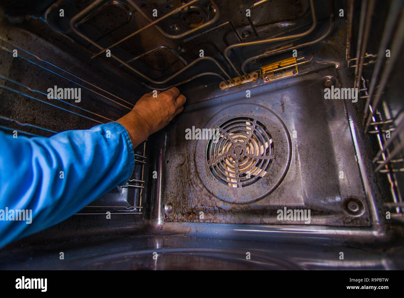 Profesional handyman fixing the motor fan in the oven Stock Photo - Alamy
